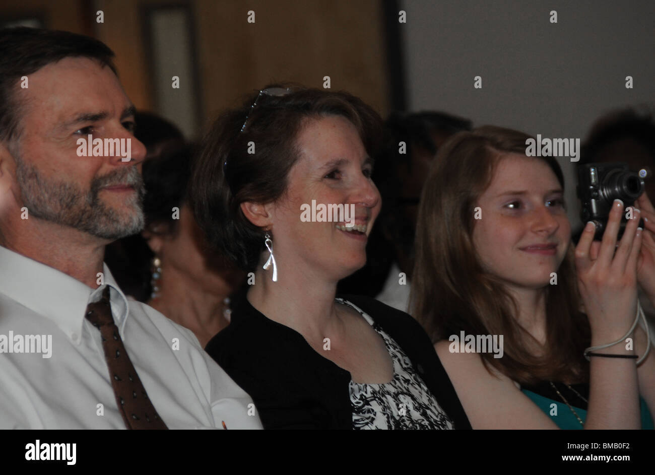 A family watches as their daughter receives her high school diploma ...