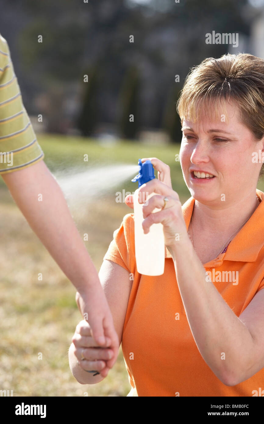 A Mother Spraying Insect Repellent On A Child's Arm Stock Photo - Alamy