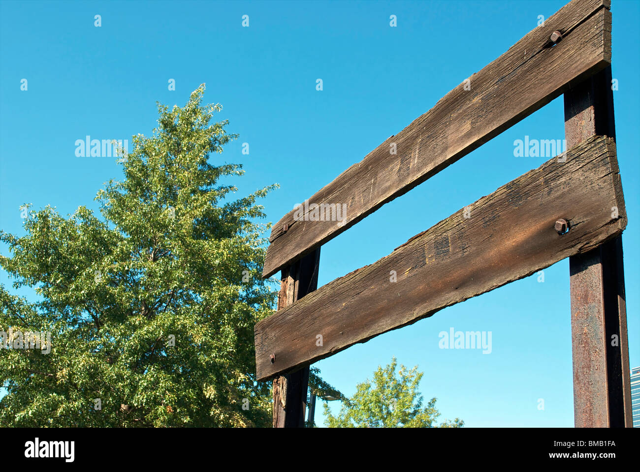 old faded wooden sign with tree in background against blue sky Stock ...