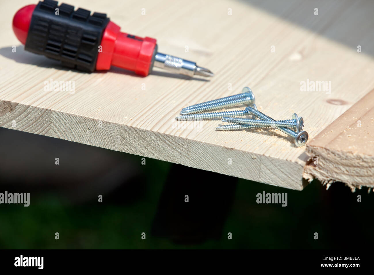 carpentry: screwdriver, screws and wood planks. small GRIP Stock Photo ...