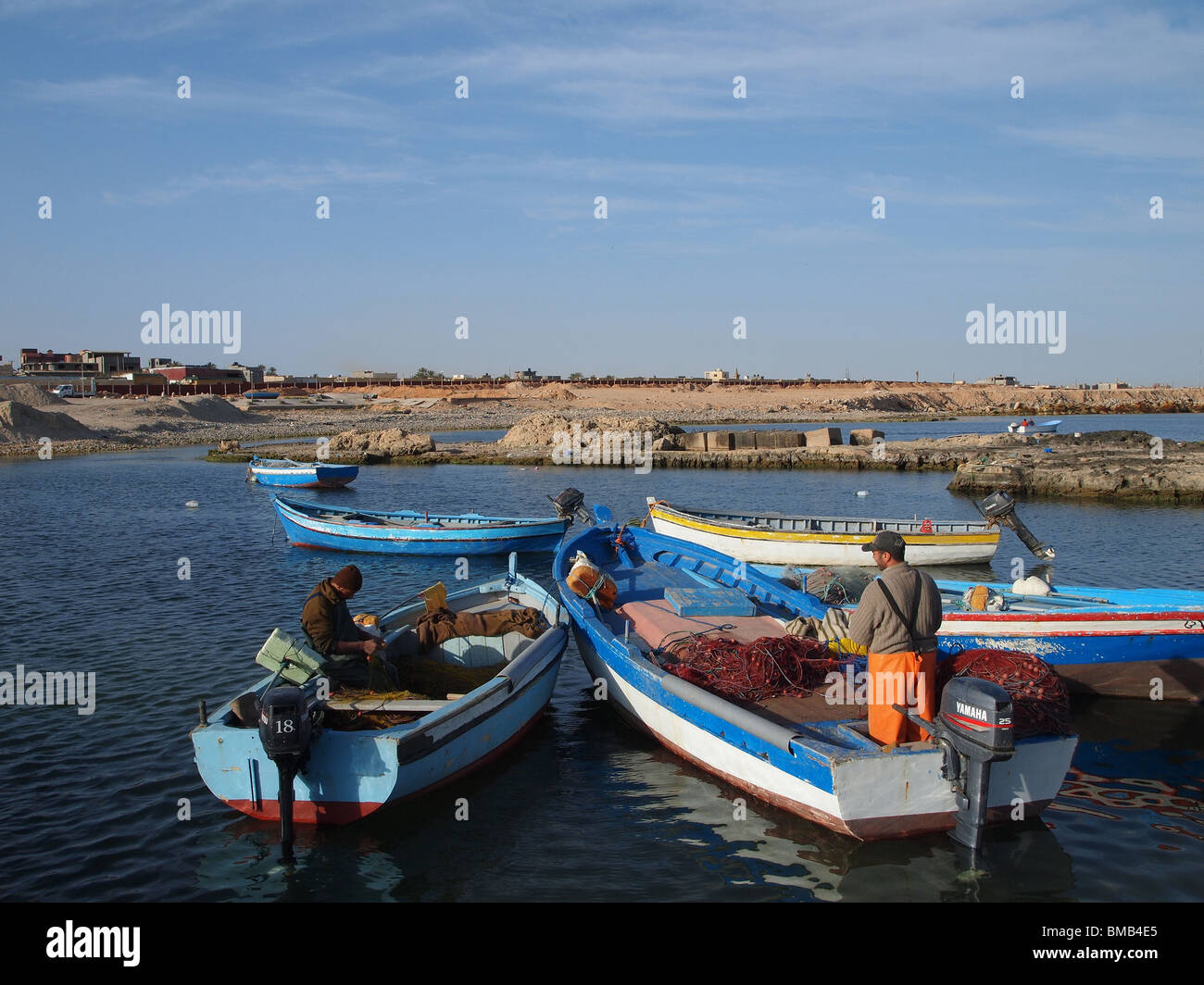 Fishermen working on their nets in a small harbour in Tripoli, Libya ...