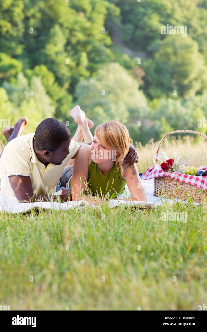 portrait of young multiethnic couple picnicking in park Stock Photo - Alamy