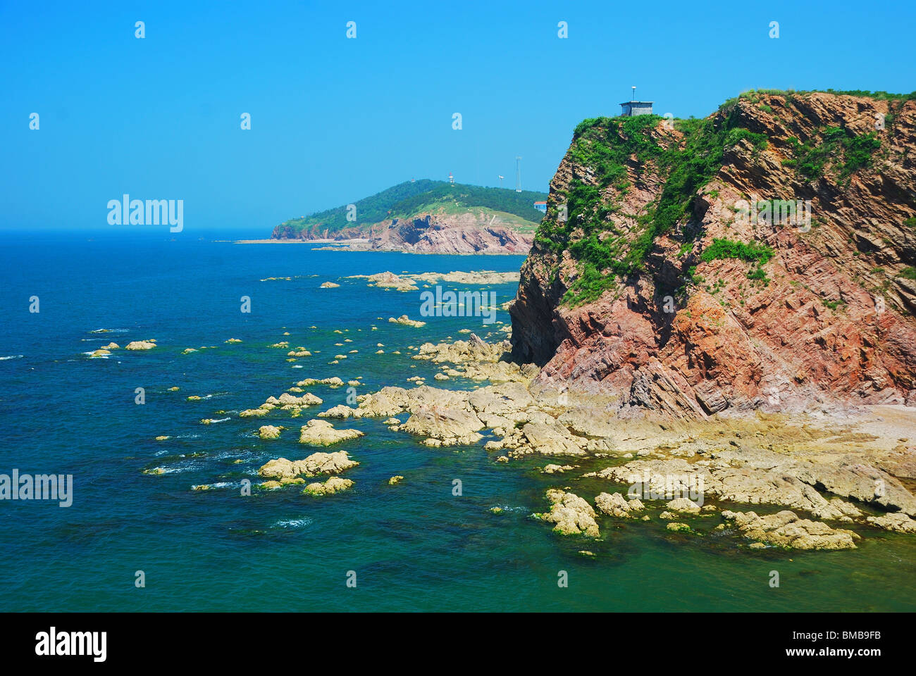Cliff at sea shore with rocks and island Stock Photo - Alamy