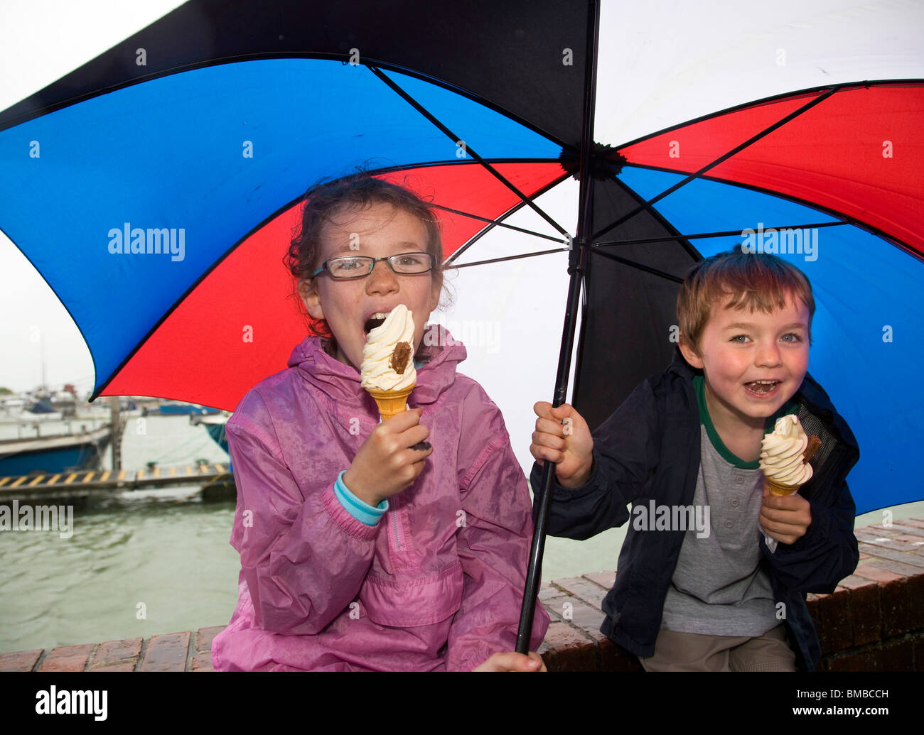 Children Eating Ice Cream under an Umbrella Stock Photo - Alamy