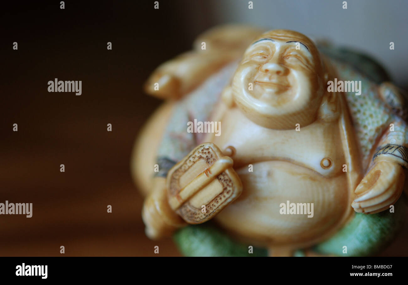 Smiling Buddha miniature figurine Stock Photo - Alamy
