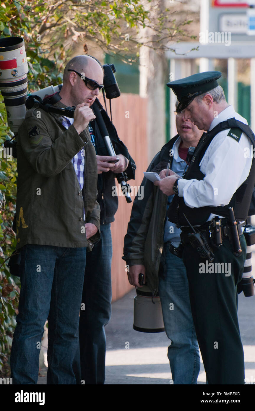 Police officer records the names of press photographers after being ...