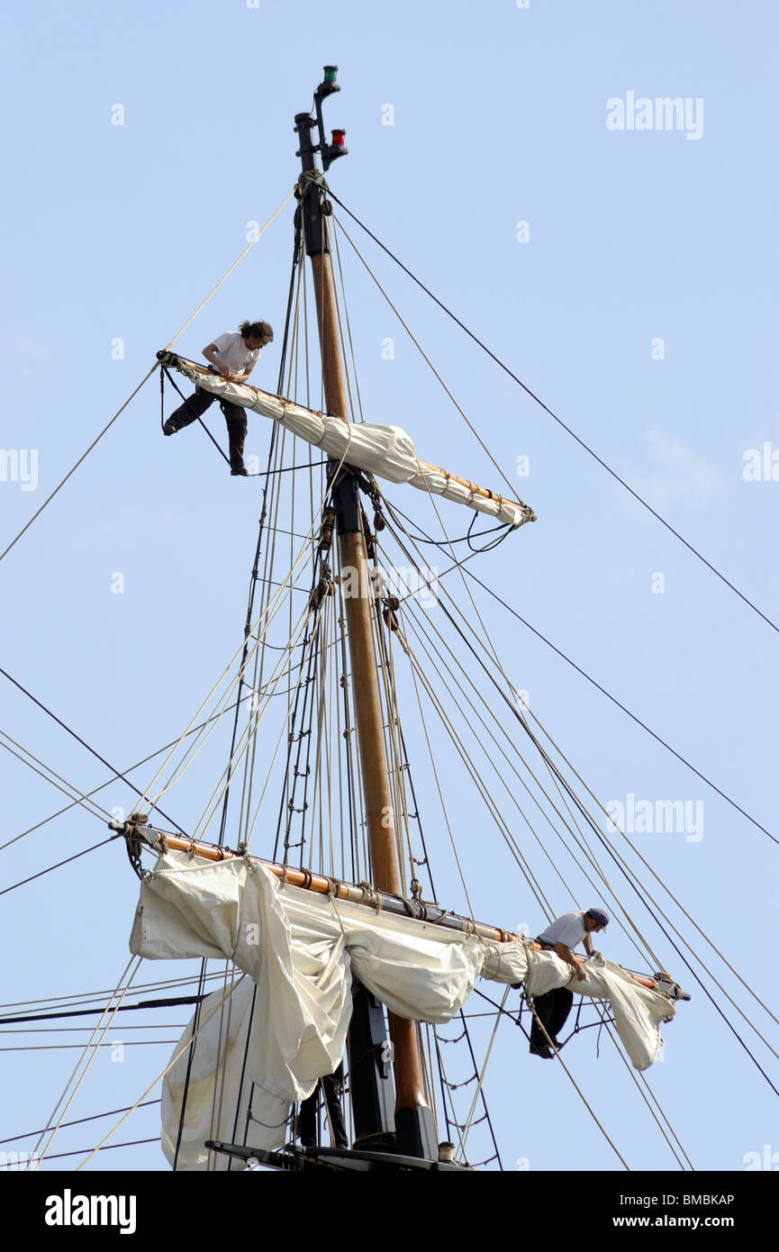 Sailors securing the sails of sailing ship, port of Brest, Brittany ...