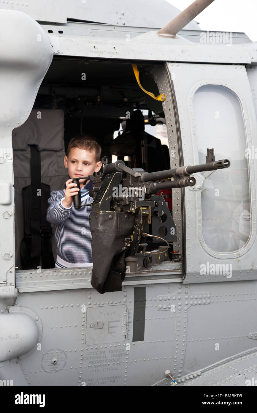 small boy gingerly holds trigger handle of port gun in search & rescue ...