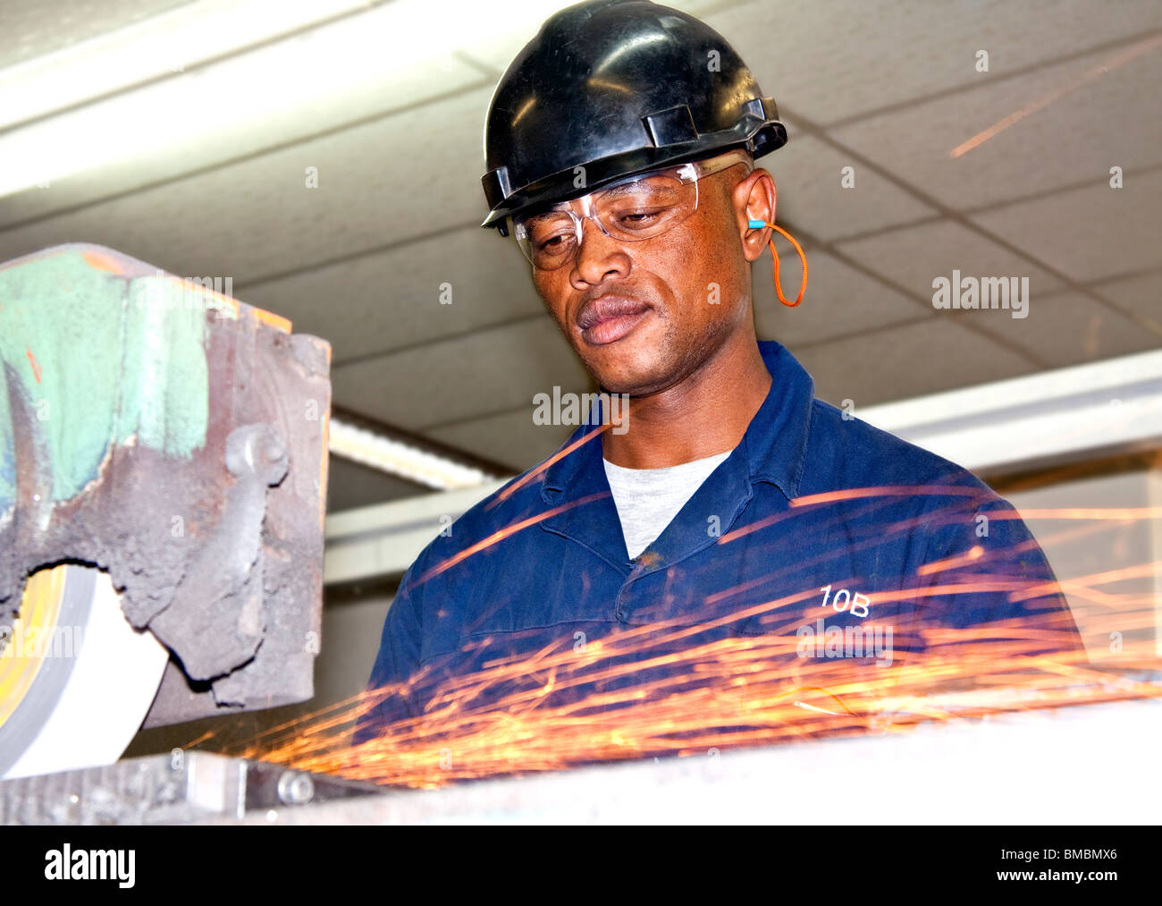A man grinding a piece of metal Stock Photo - Alamy