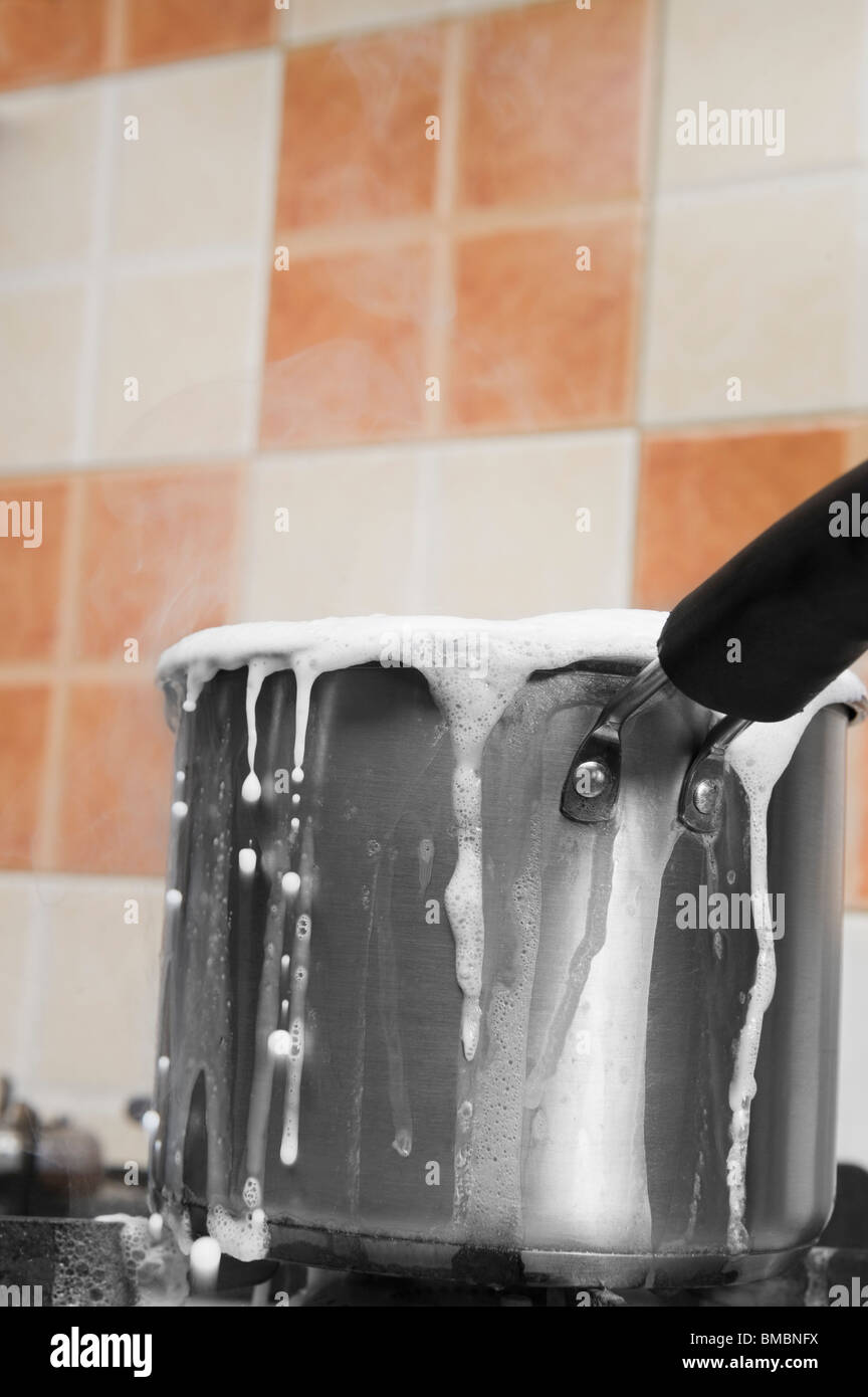 Milk boiling over a pan Stock Photo - Alamy