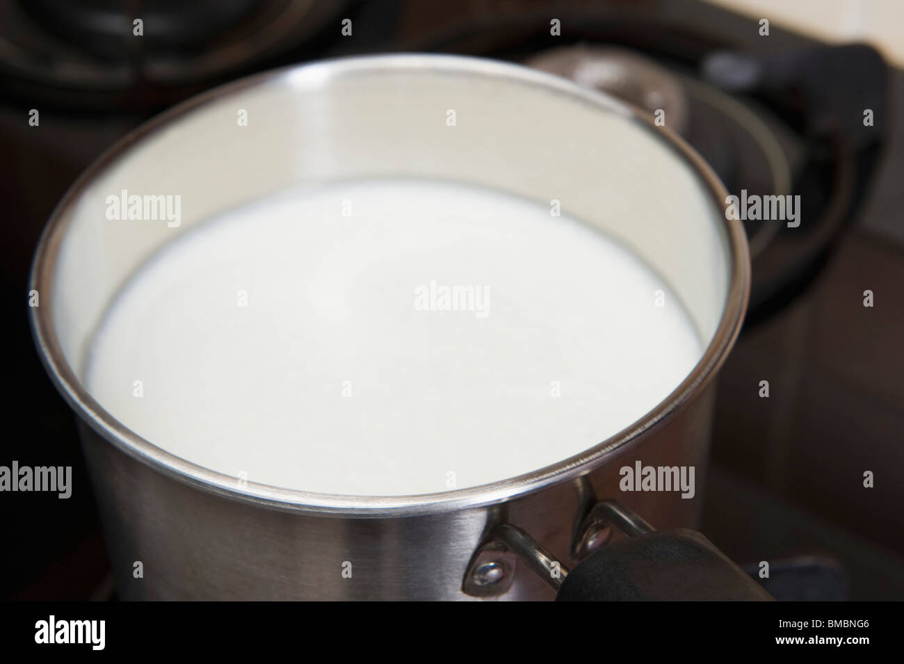 Milk in a saucepan on a gas stove burner Stock Photo - Alamy