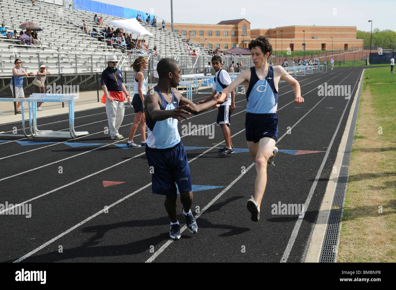2 runners in a relay race in a track event Stock Photo - Alamy