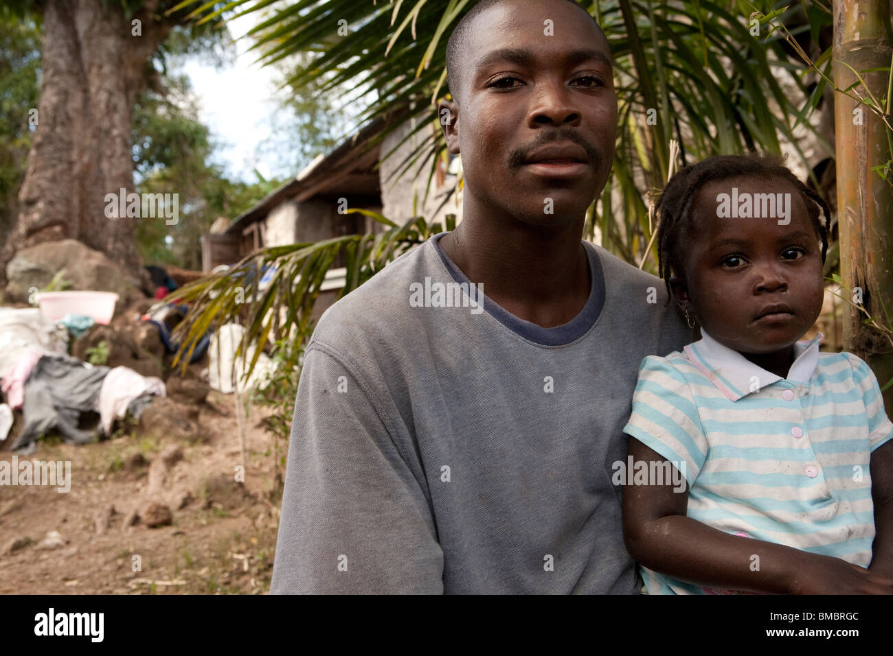 A father and daughter sit outside their home in Marmelade, Haiti Stock ...