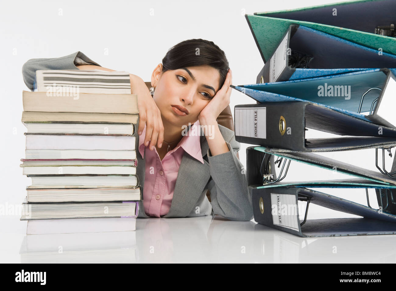 Stack of books in front of a businesswoman at desk Stock Photo - Alamy