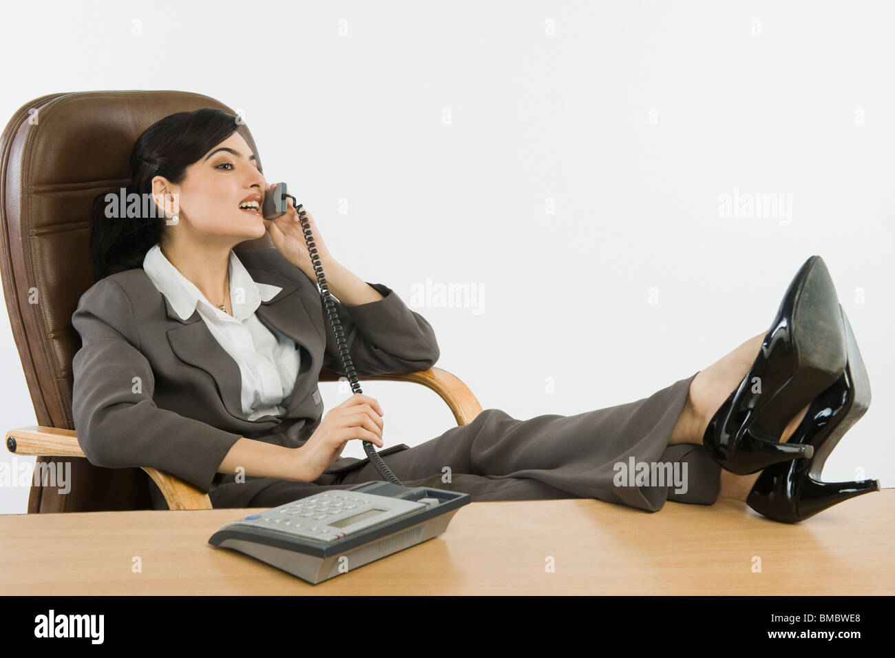 Full length businesswoman relaxing feet up hi-res stock photography and ...