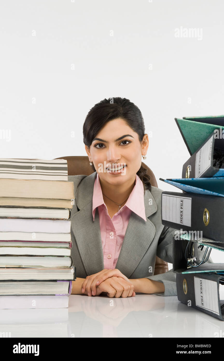 Stack of books and binders in front of a businesswoman at desk Stock ...