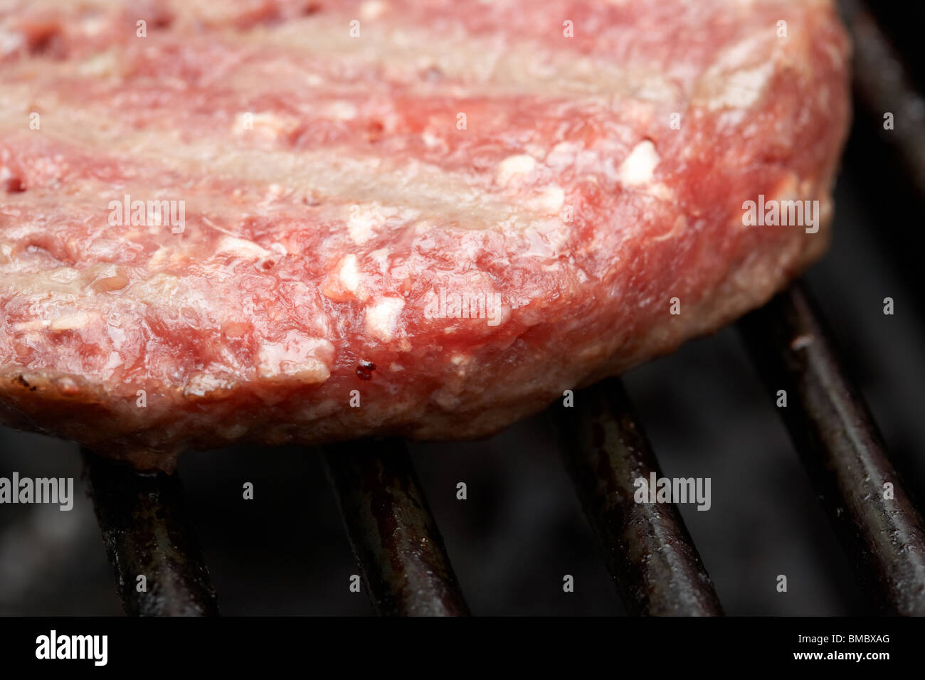 partially cooked raw steak burgers cooking on a barbeque grill Stock ...
