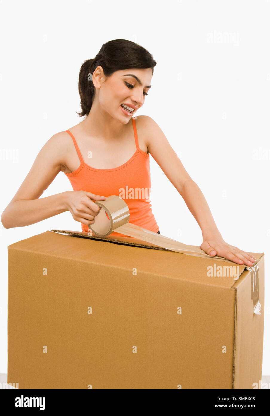 Woman packing cardboard by packing tape Stock Photo - Alamy