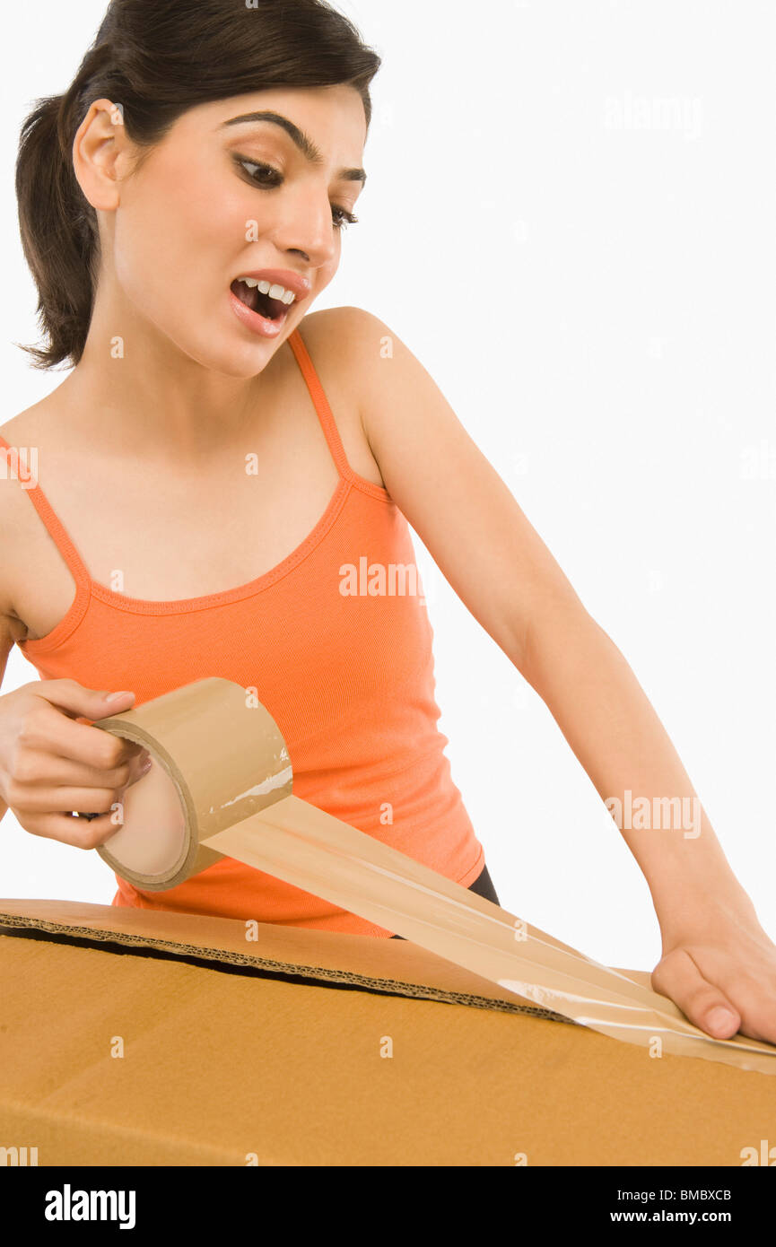 Woman packing cardboard by packing tape Stock Photo - Alamy