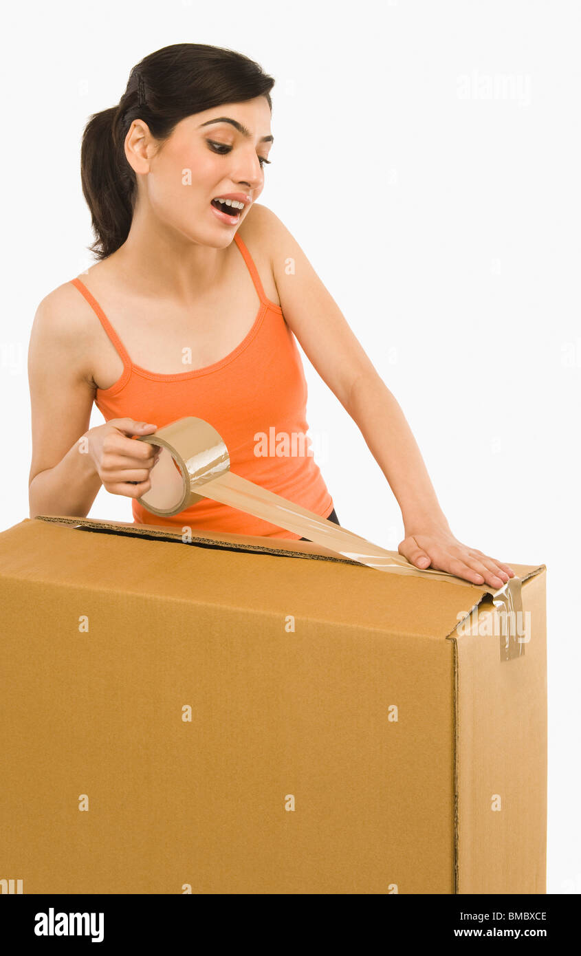 Woman packing cardboard by packing tape Stock Photo - Alamy