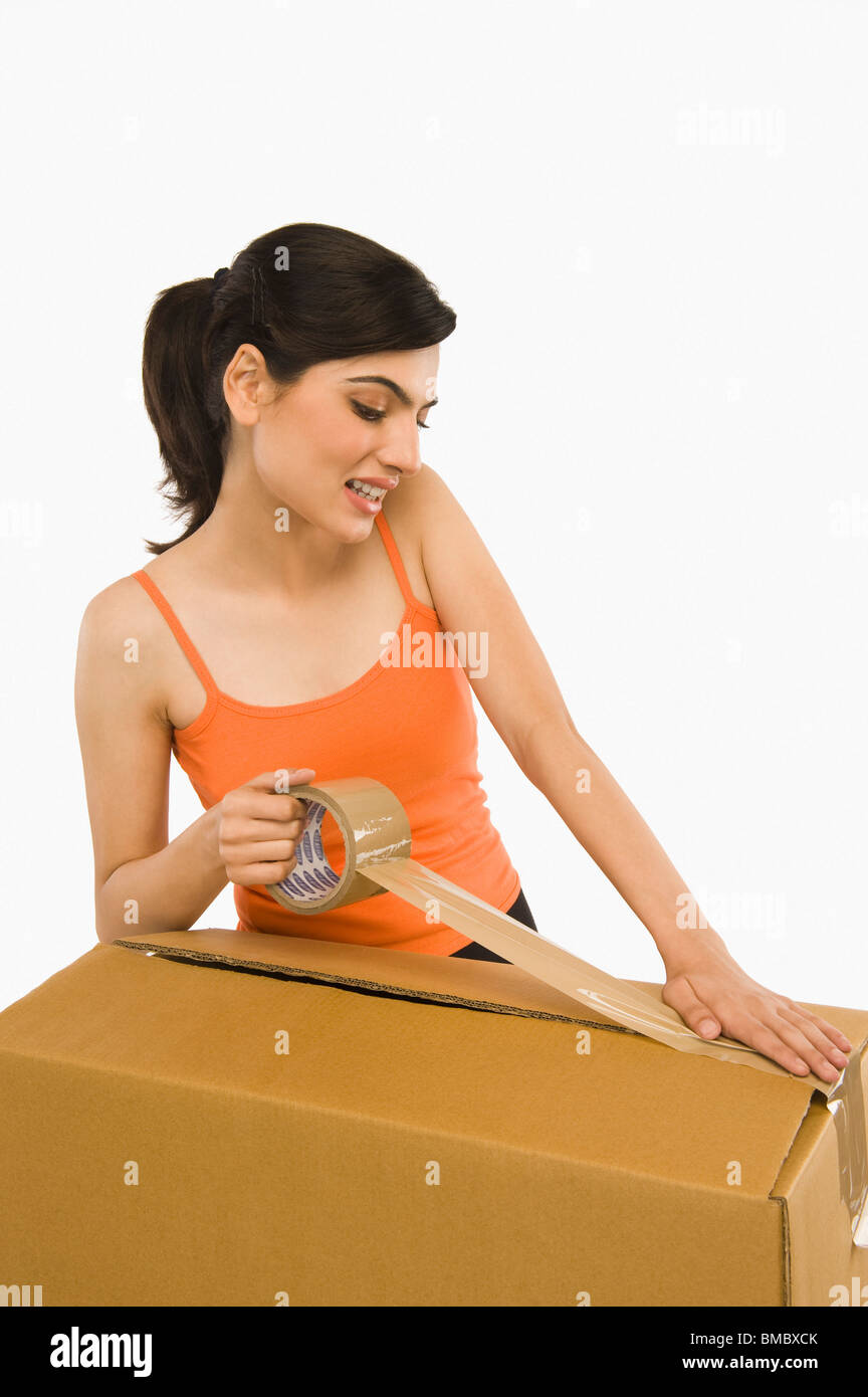 Woman packing cardboard by packing tape Stock Photo - Alamy