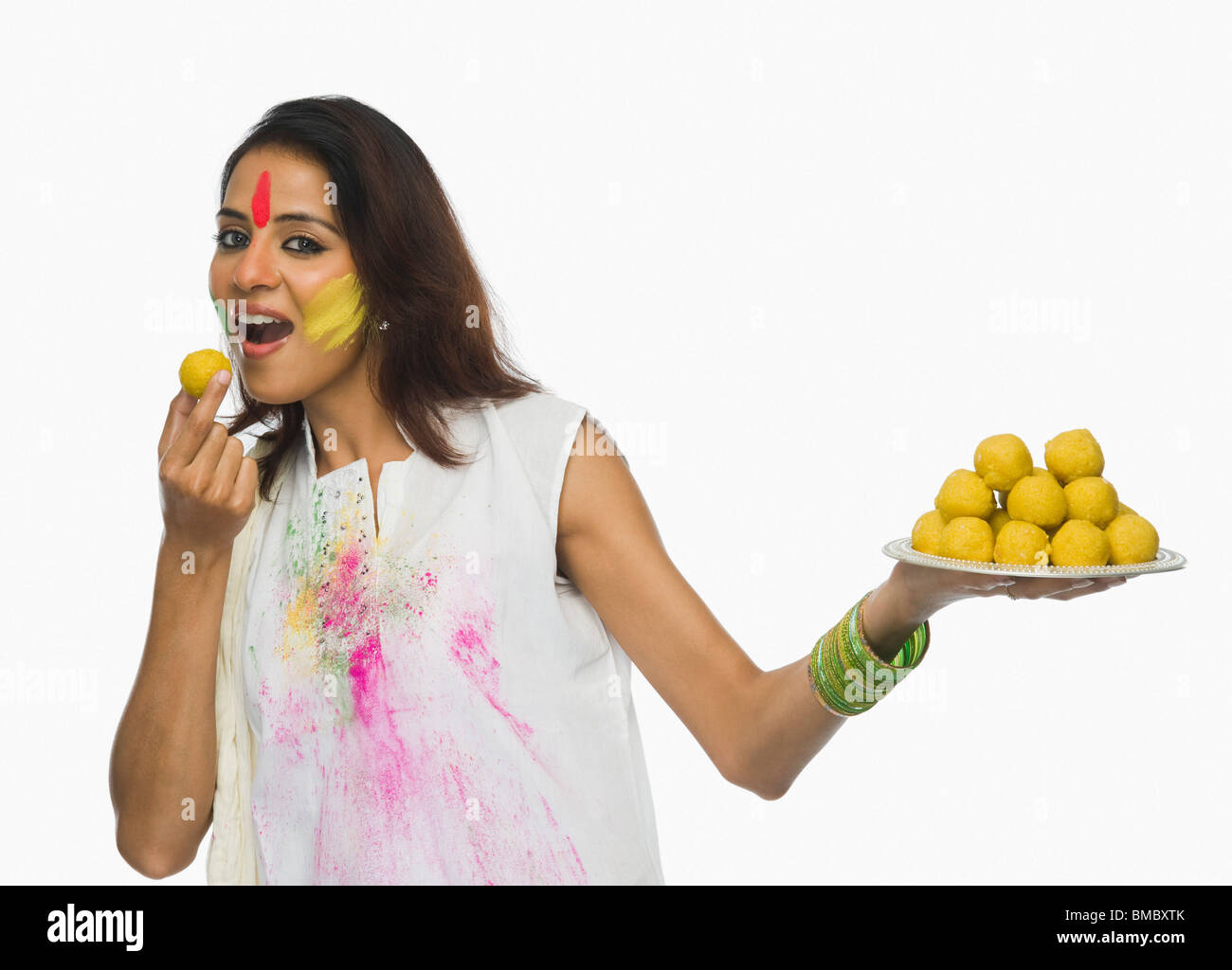 Woman eating Laddu on Holi Stock Photo - Alamy
