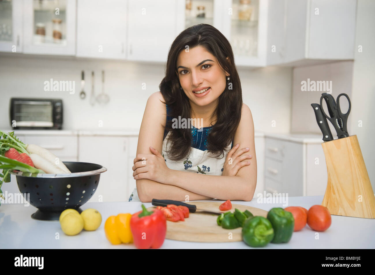 Portrait of a woman leaning on a kitchen counter Stock Photo - Alamy