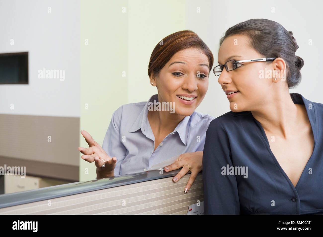 Two businesswomen gossiping in an office Stock Photo - Alamy