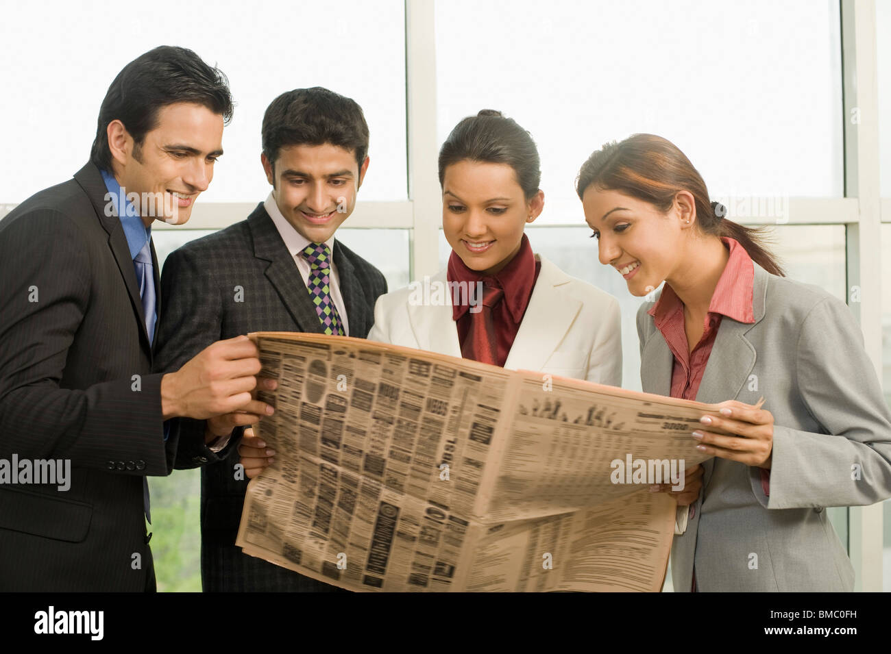 Business executives reading a newspaper Stock Photo - Alamy