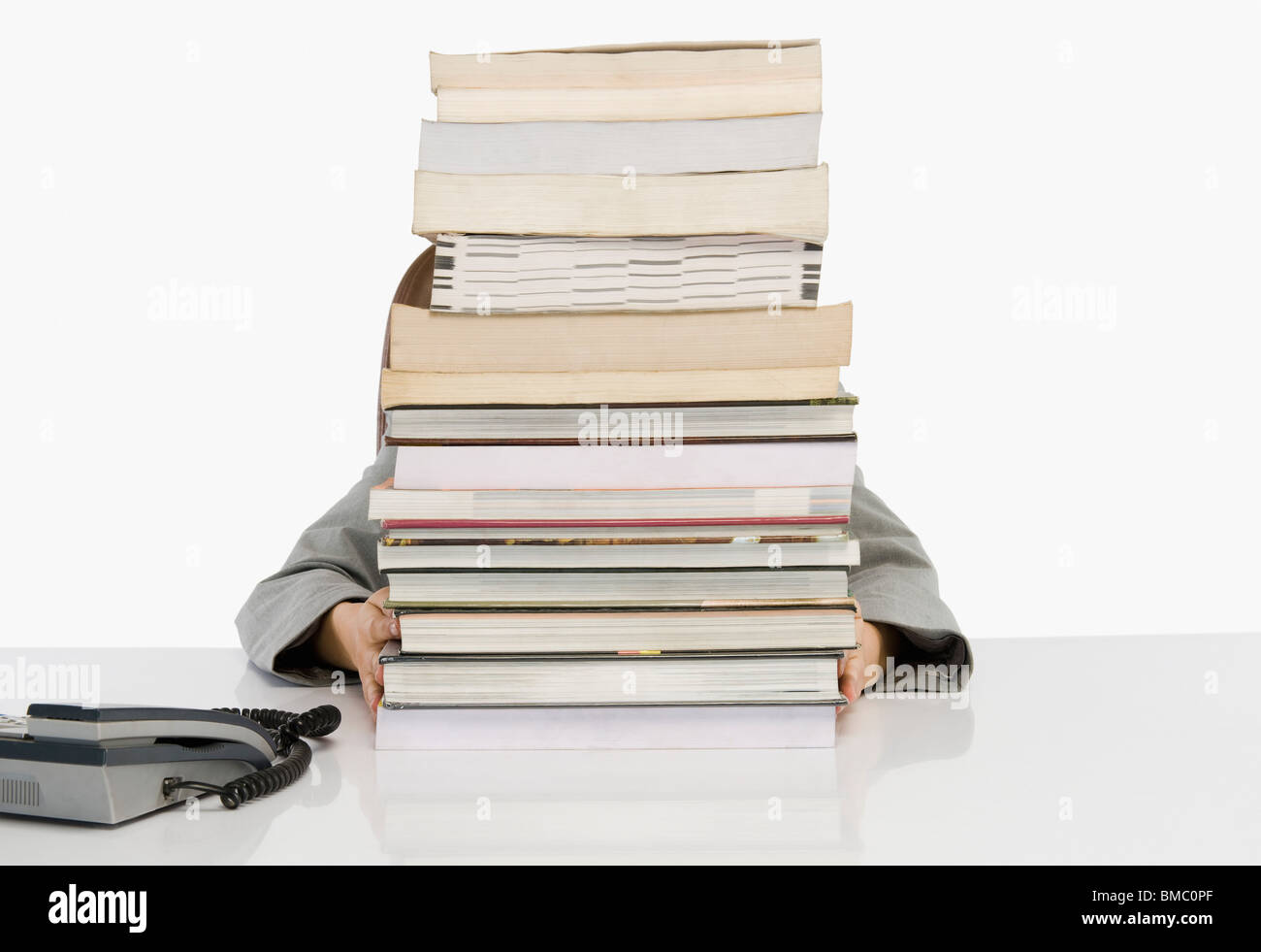 Business person hiding behind a stack of books Stock Photo - Alamy