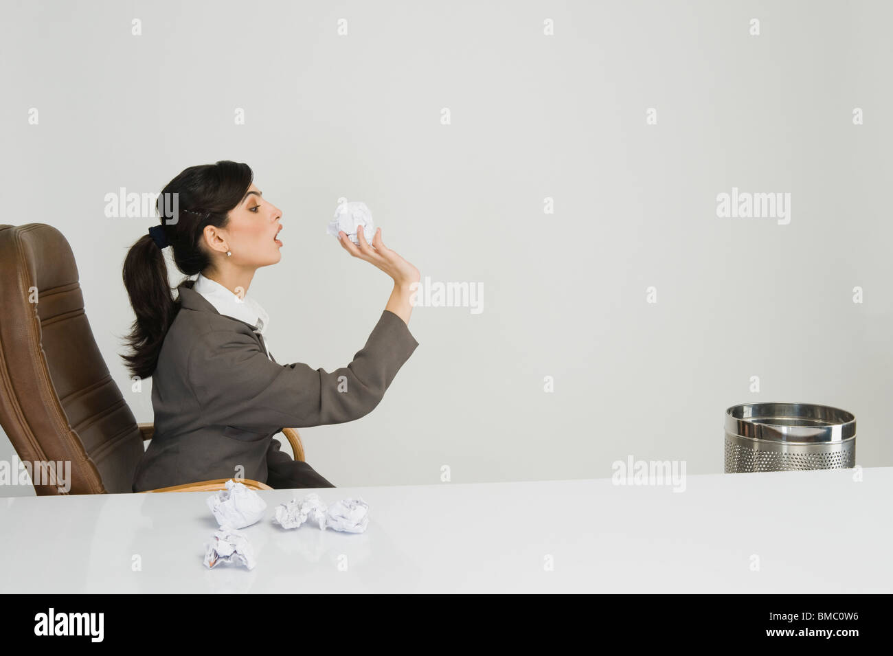 Businesswoman throwing crumpled paper into a wastepaper basket Stock ...