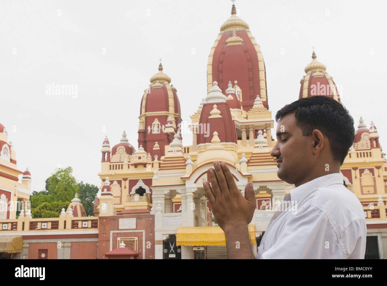 Man praying in front of a temple, Laxminarayan Temple, New Delhi, India ...