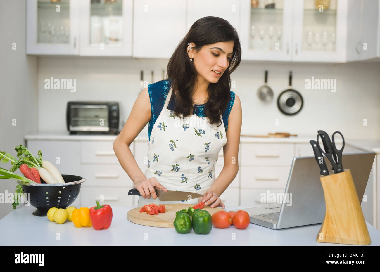 Woman cooking with the recipe on a laptop Stock Photo - Alamy