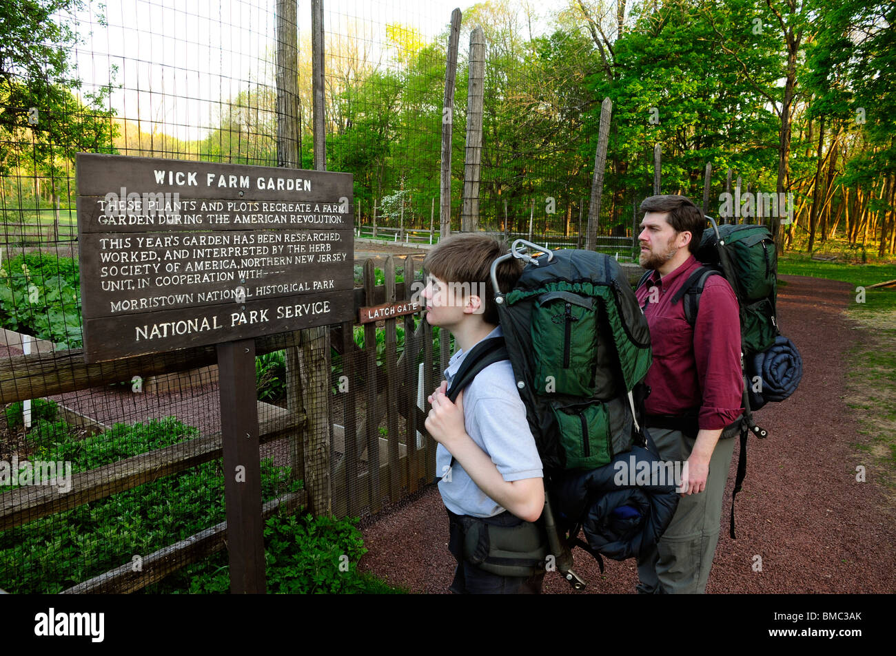Father and son hikers reading the sign at the Wick Farm Garden in the ...