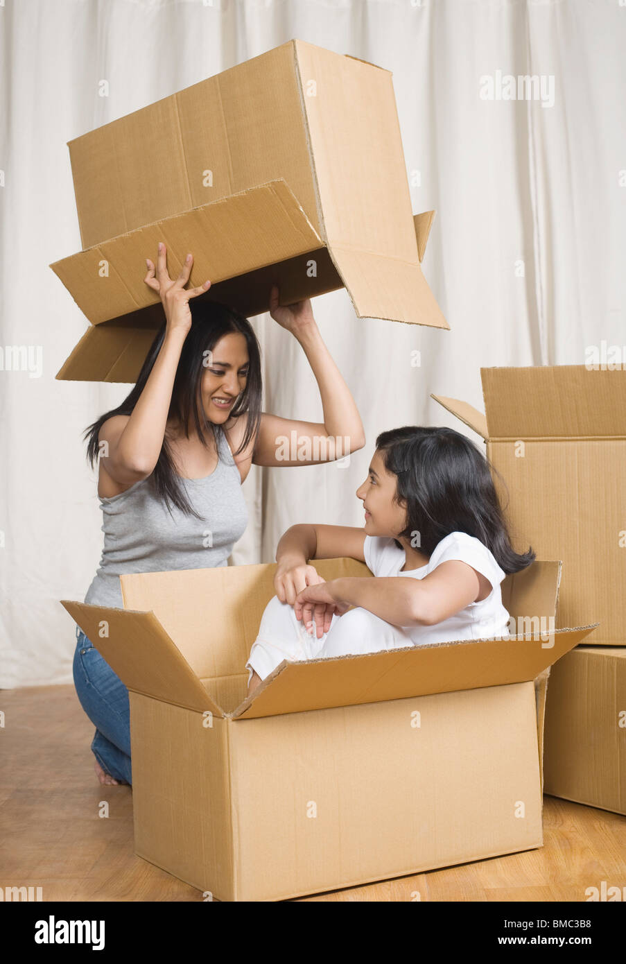 Woman and her daughter playing with cardboard boxes Stock Photo - Alamy