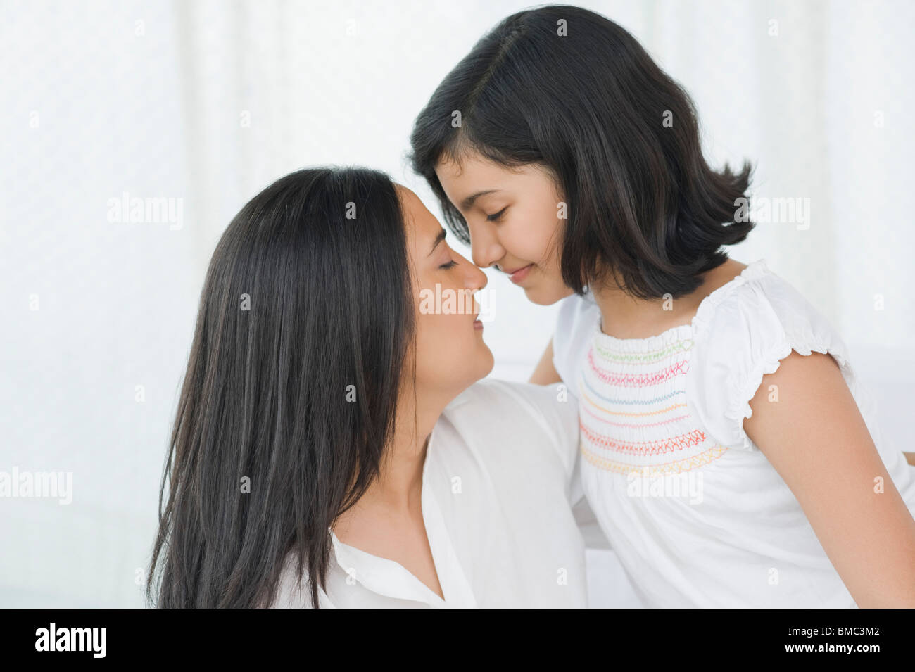 Woman rubbing noses with her daughter Stock Photo - Alamy