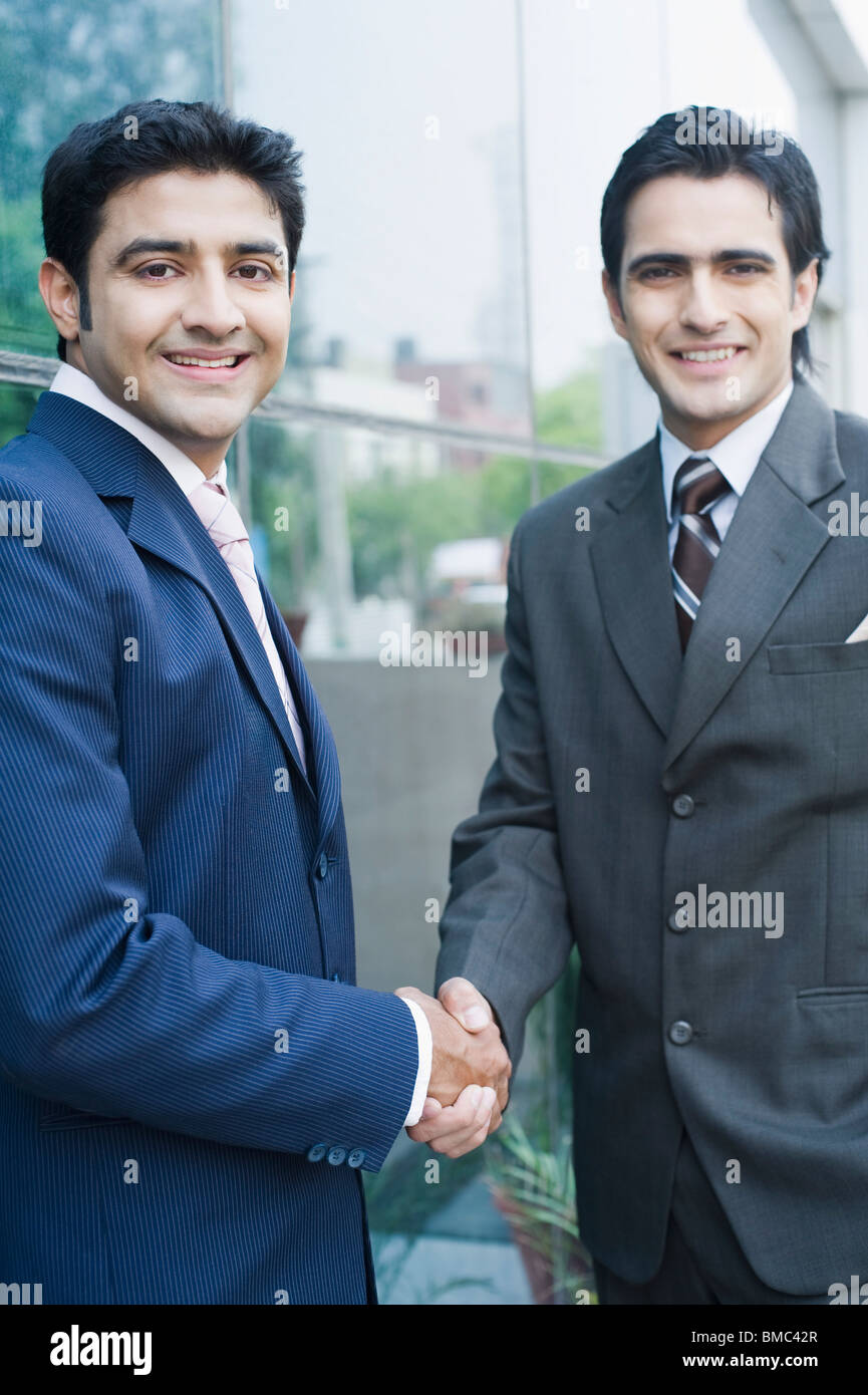 Two businessmen shaking hands Stock Photo - Alamy