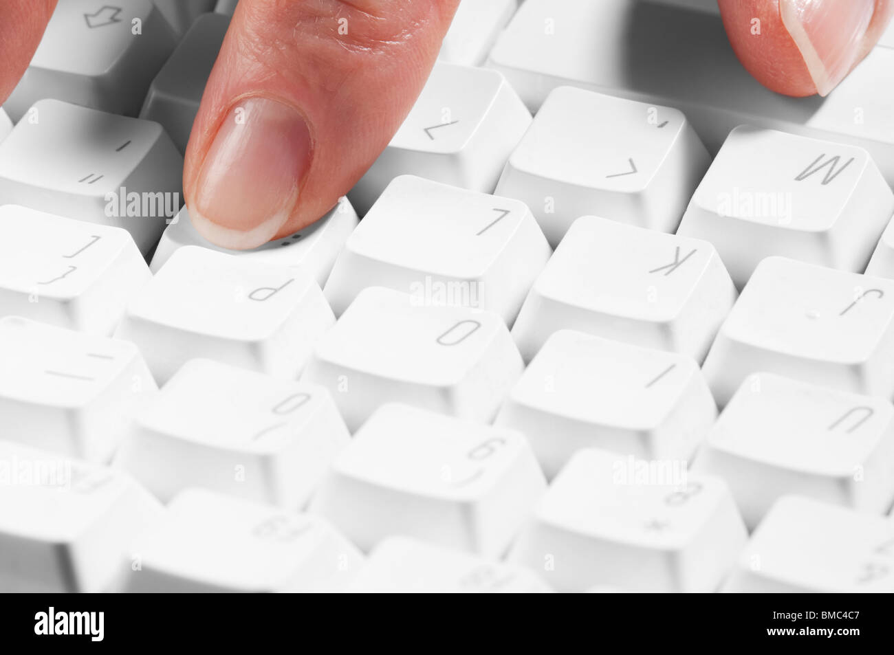 Fingers of an employee typing on a white computer keyboard. The image ...