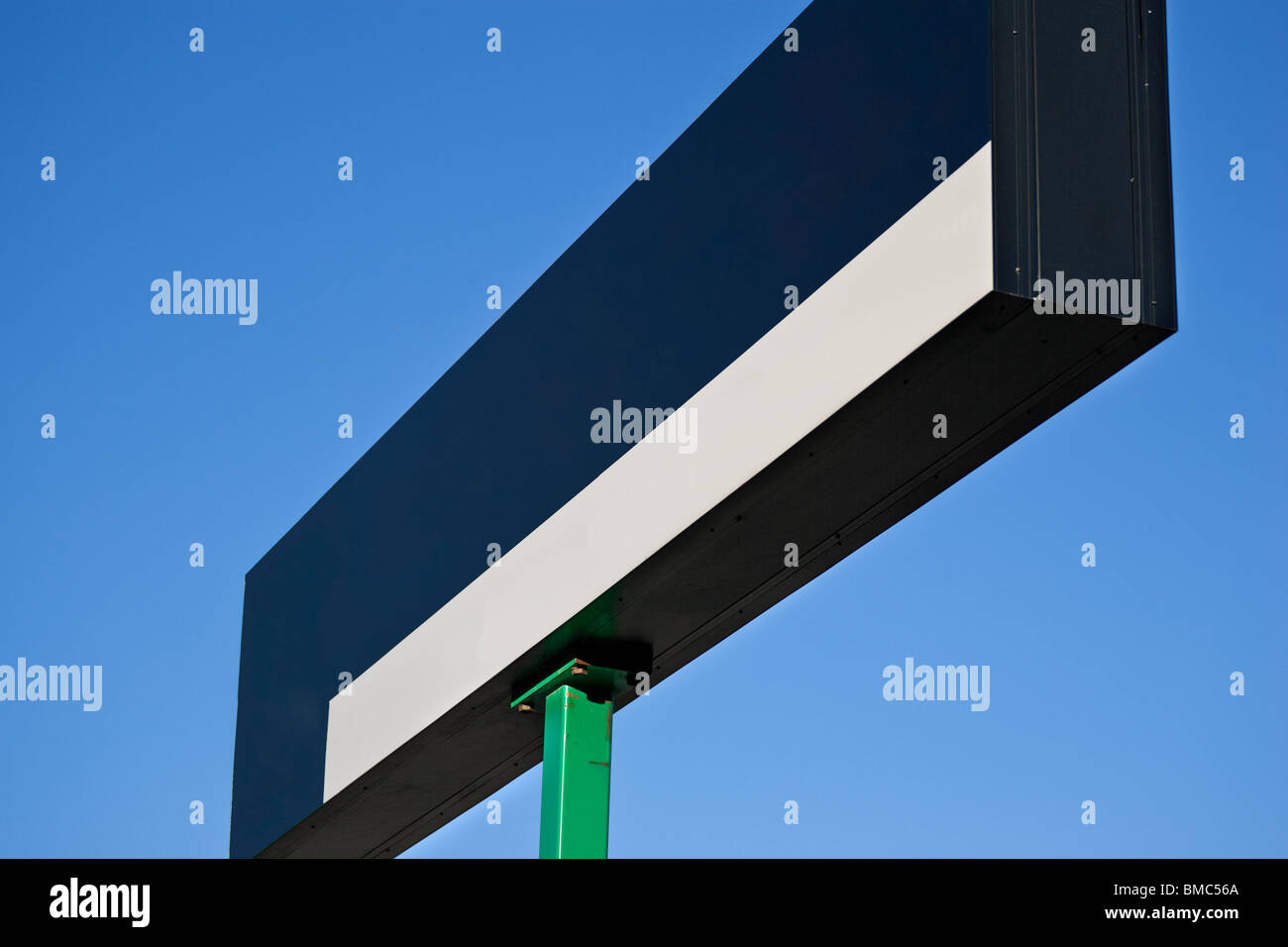 A large blank sign on a green pole, against a blue sky Stock Photo - Alamy