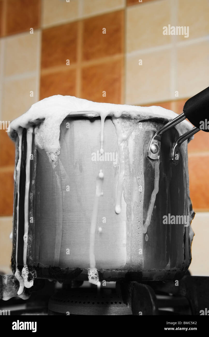 Milk boiling over a pan Stock Photo - Alamy