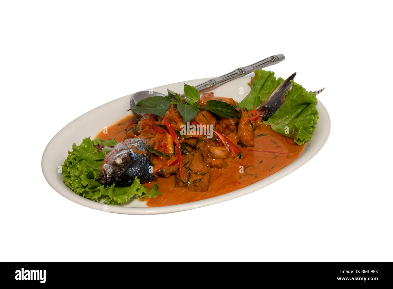 Chu Chi Pla (Thai fried fish with red curry sauce) cut out on white ...