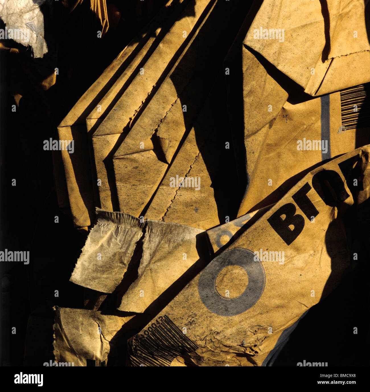 Discarded brown paper bags piled together in a dimly lit area revealing ...