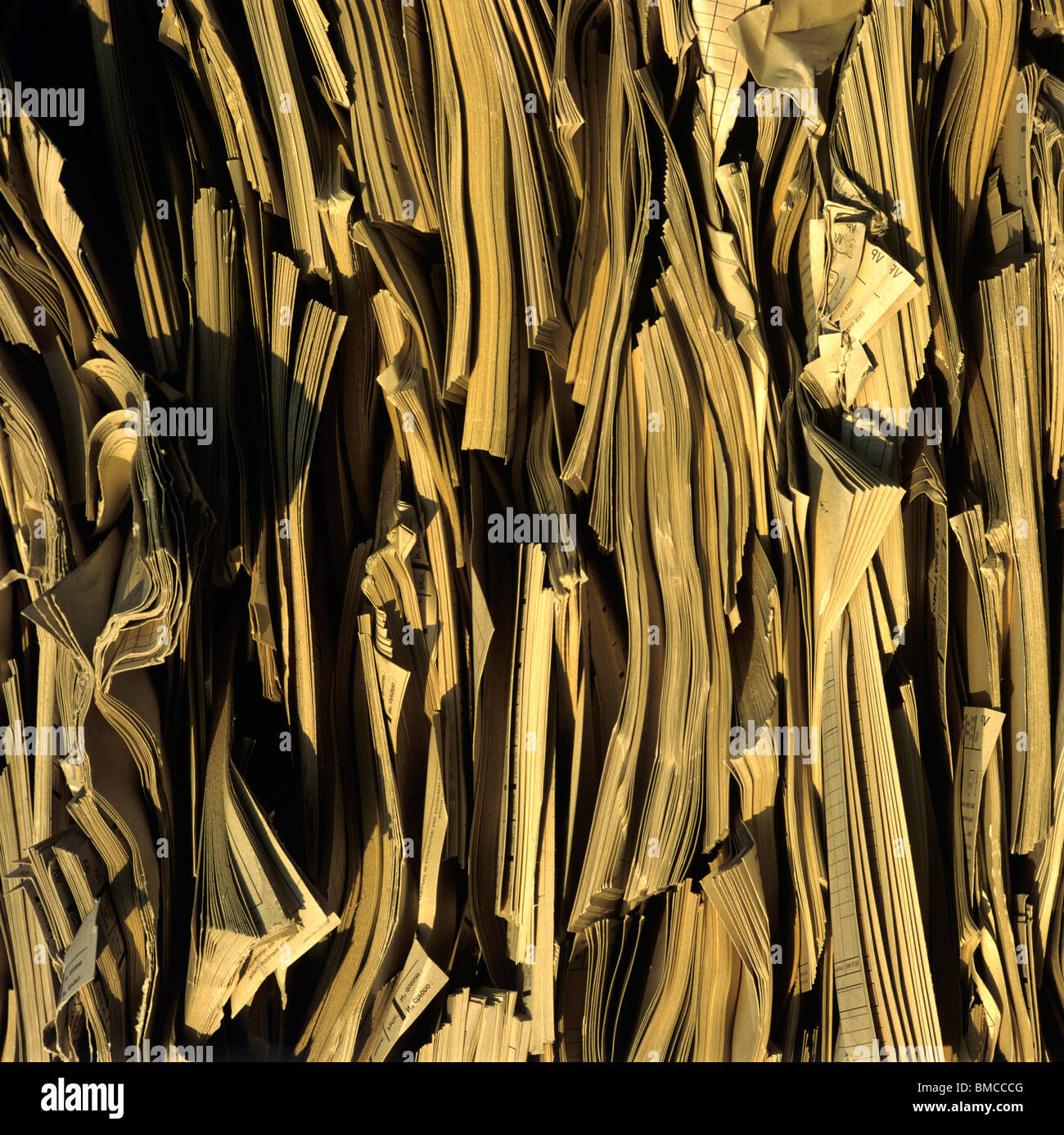 Disorganized stack of old documents piled unevenly in a storage area ...