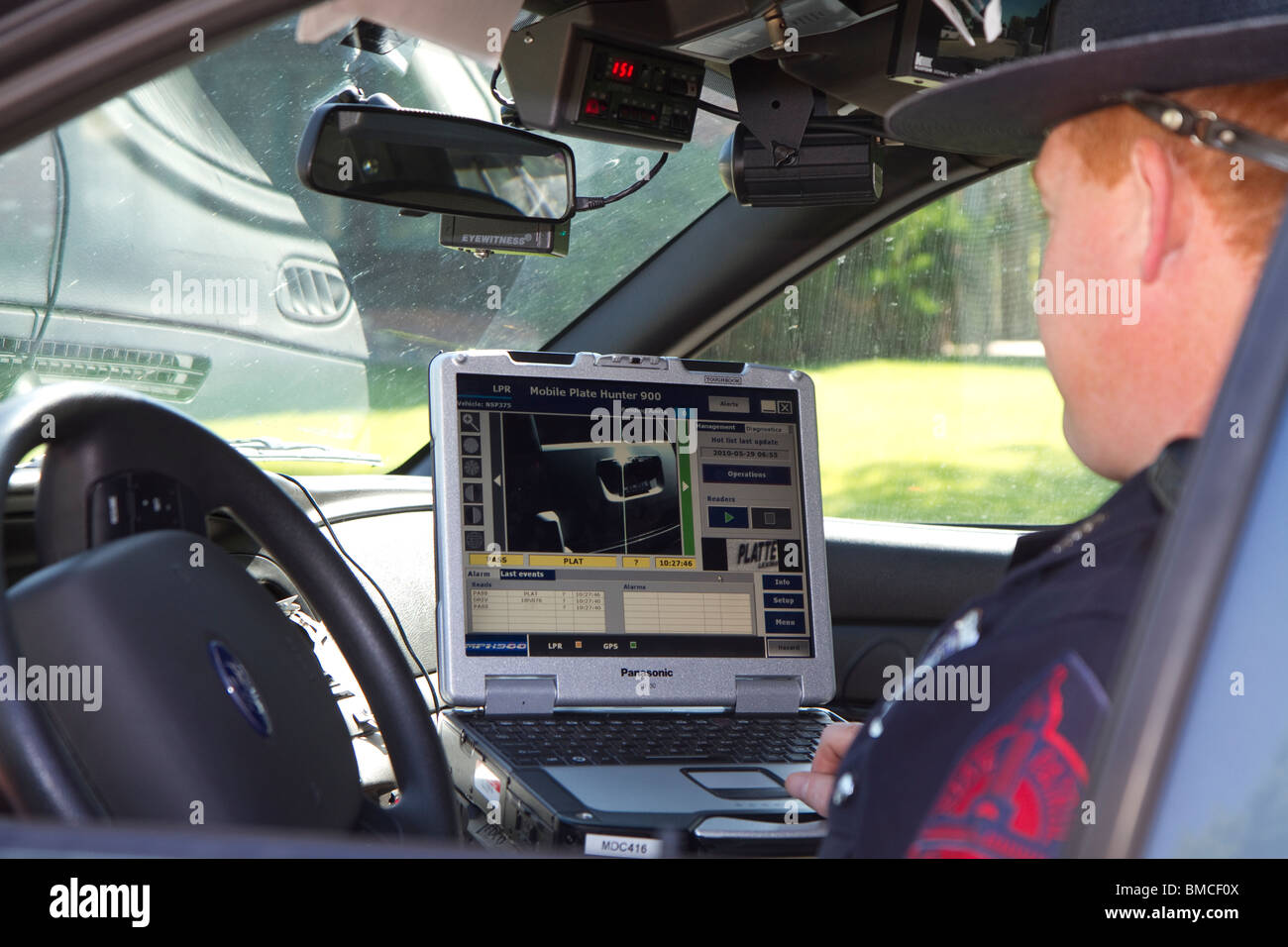 Nebraska State Trooper using laptop computer in cruiser to read output ...