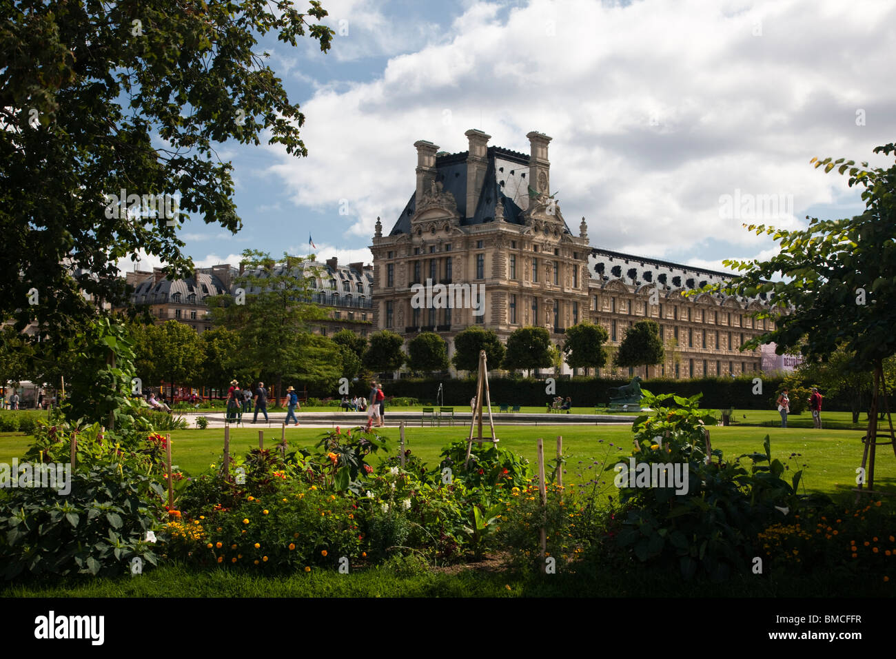 Richelieu wing of Louvre museum viewed through colorful flowers in ...
