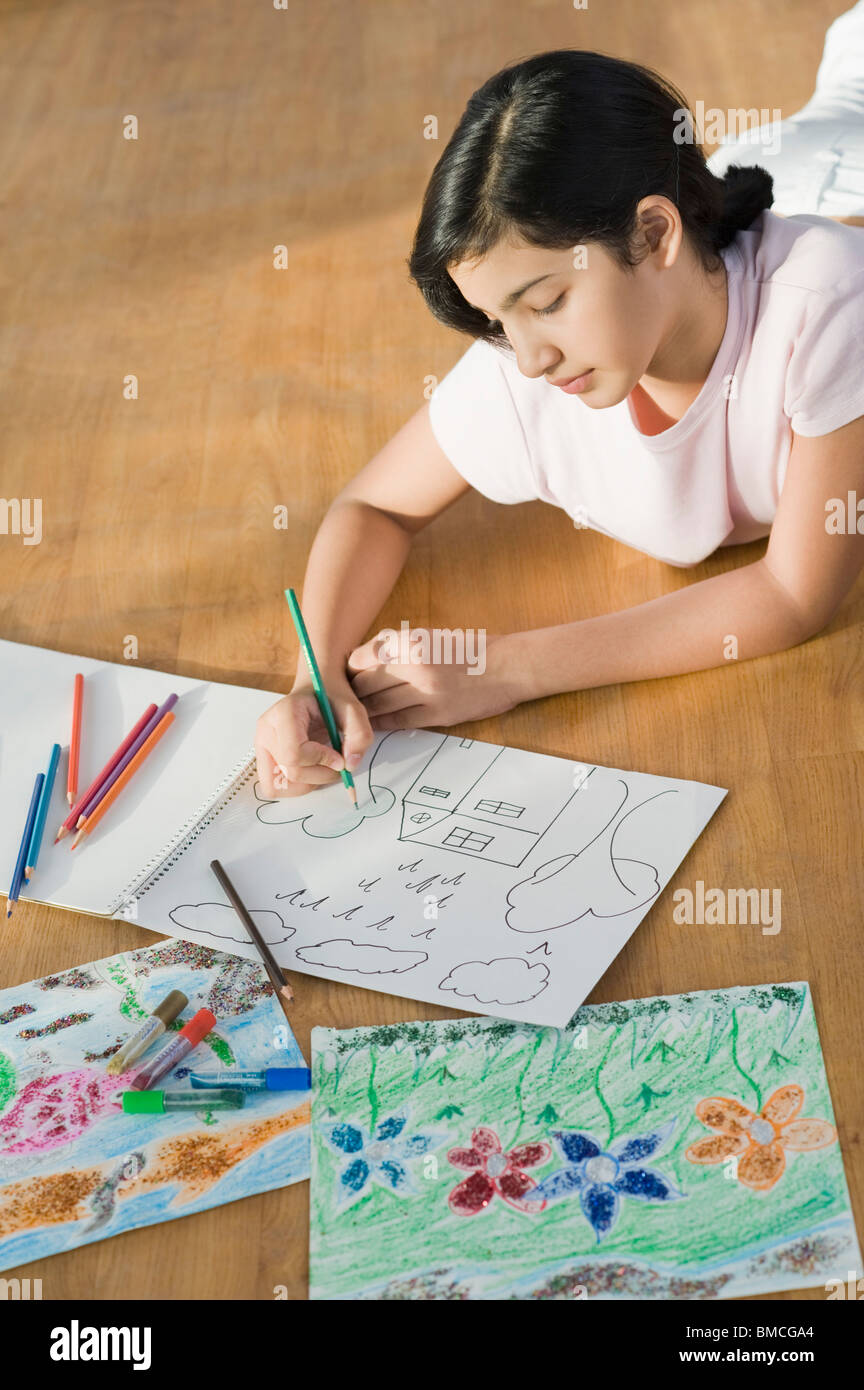 Girl lying on the floor and making a drawing Stock Photo - Alamy