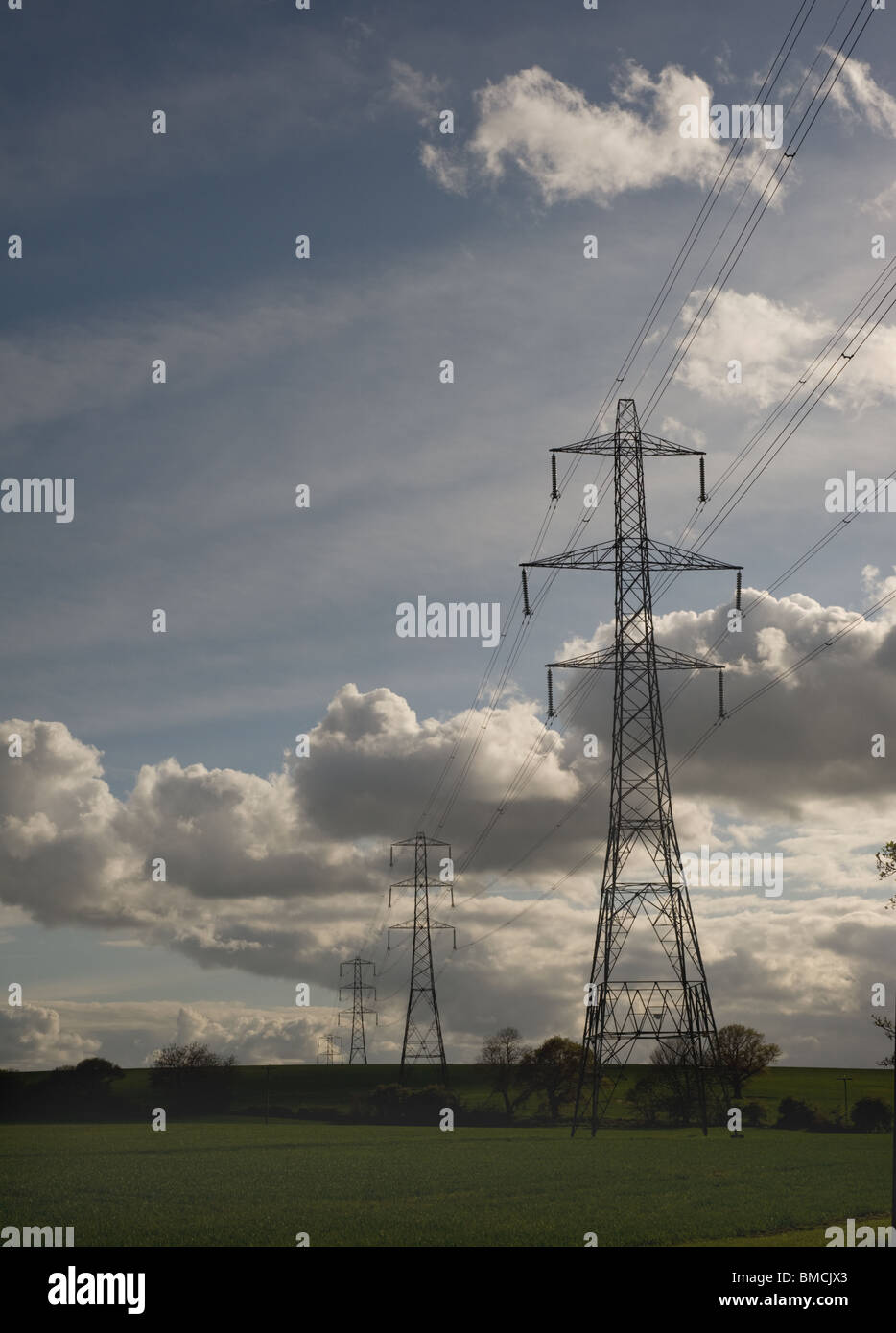 Pylons against a cloud filled sky Stock Photo - Alamy