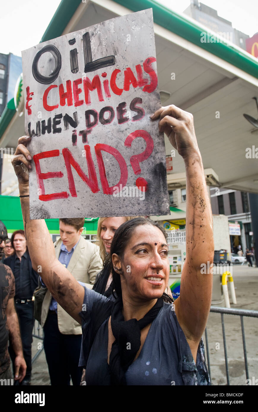 Protesters spill liquid representing oil over themselves in front of a ...