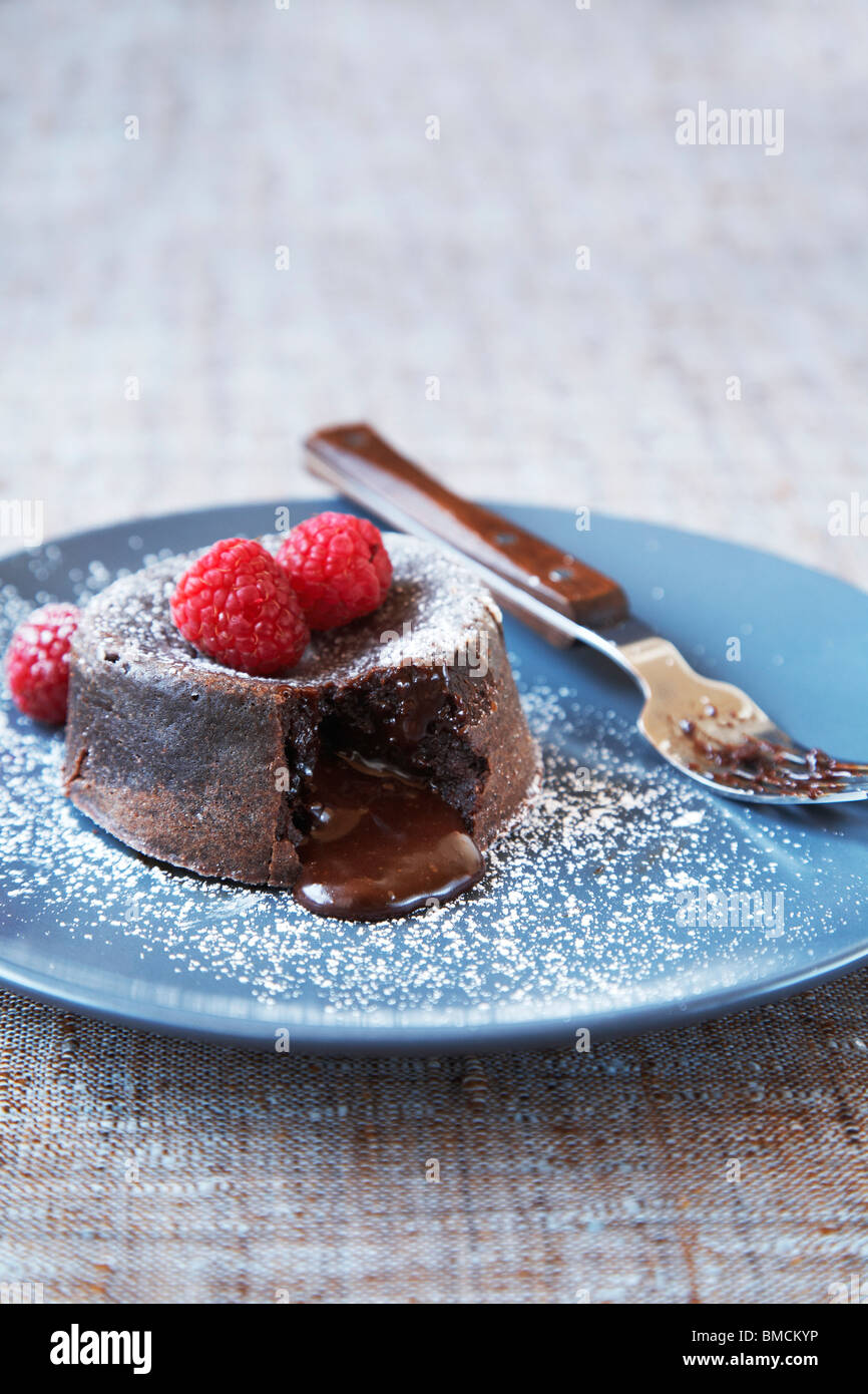 Chocolate Lava Cake with Raspberries and Icing Sugar Stock Photo - Alamy
