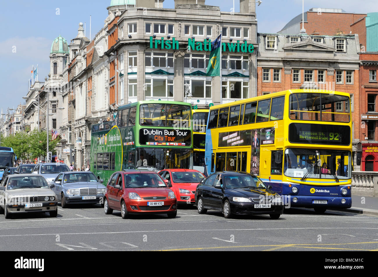 Yellow and Blue painted Dublin bus and city tour bus on O'Connell ...